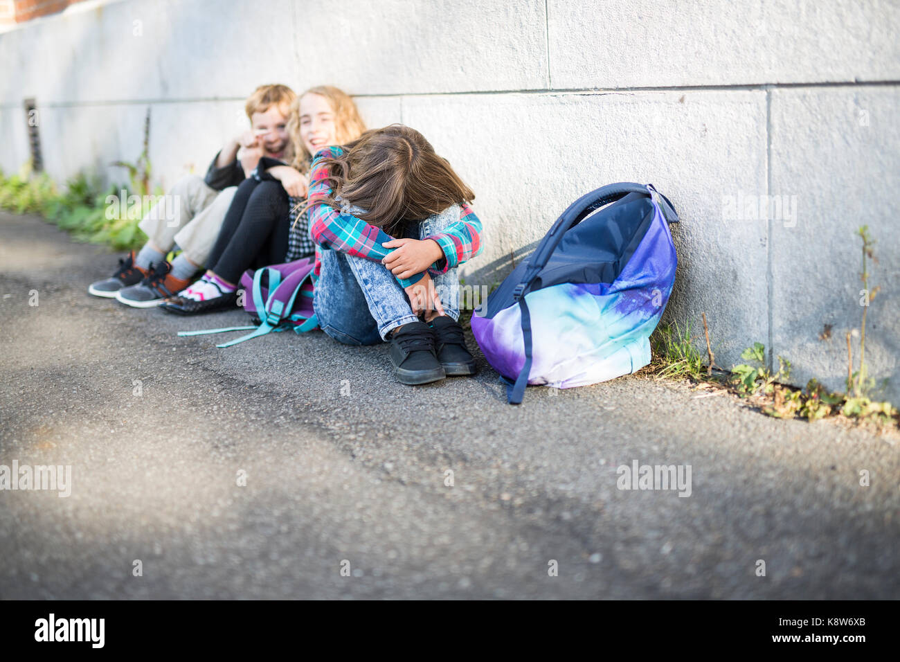 primary students outside at school standing sad Stock Photo - Alamy