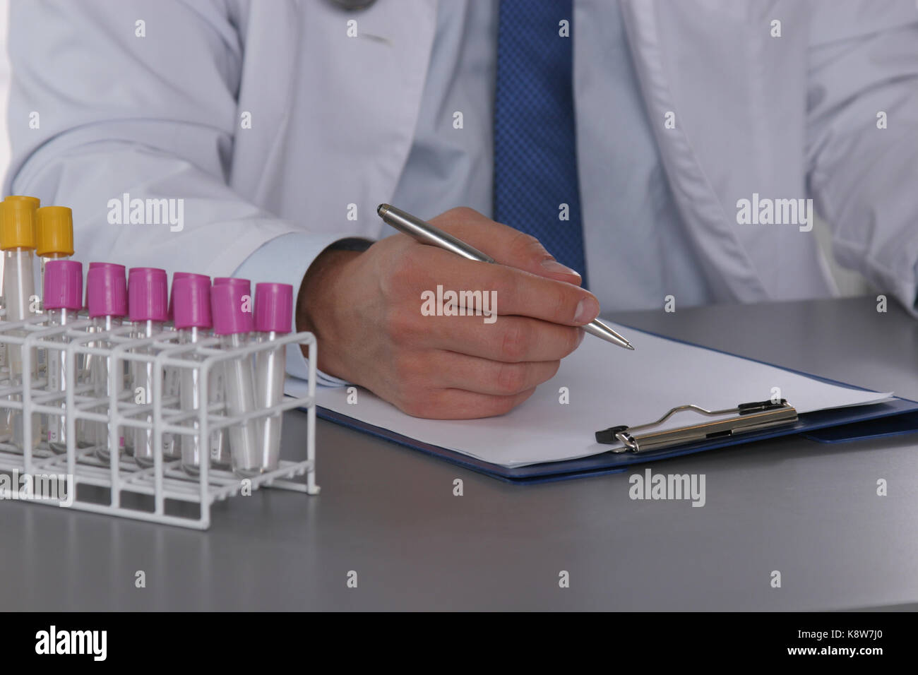 Male doctor write on the desk with test tube Stock Photo - Alamy