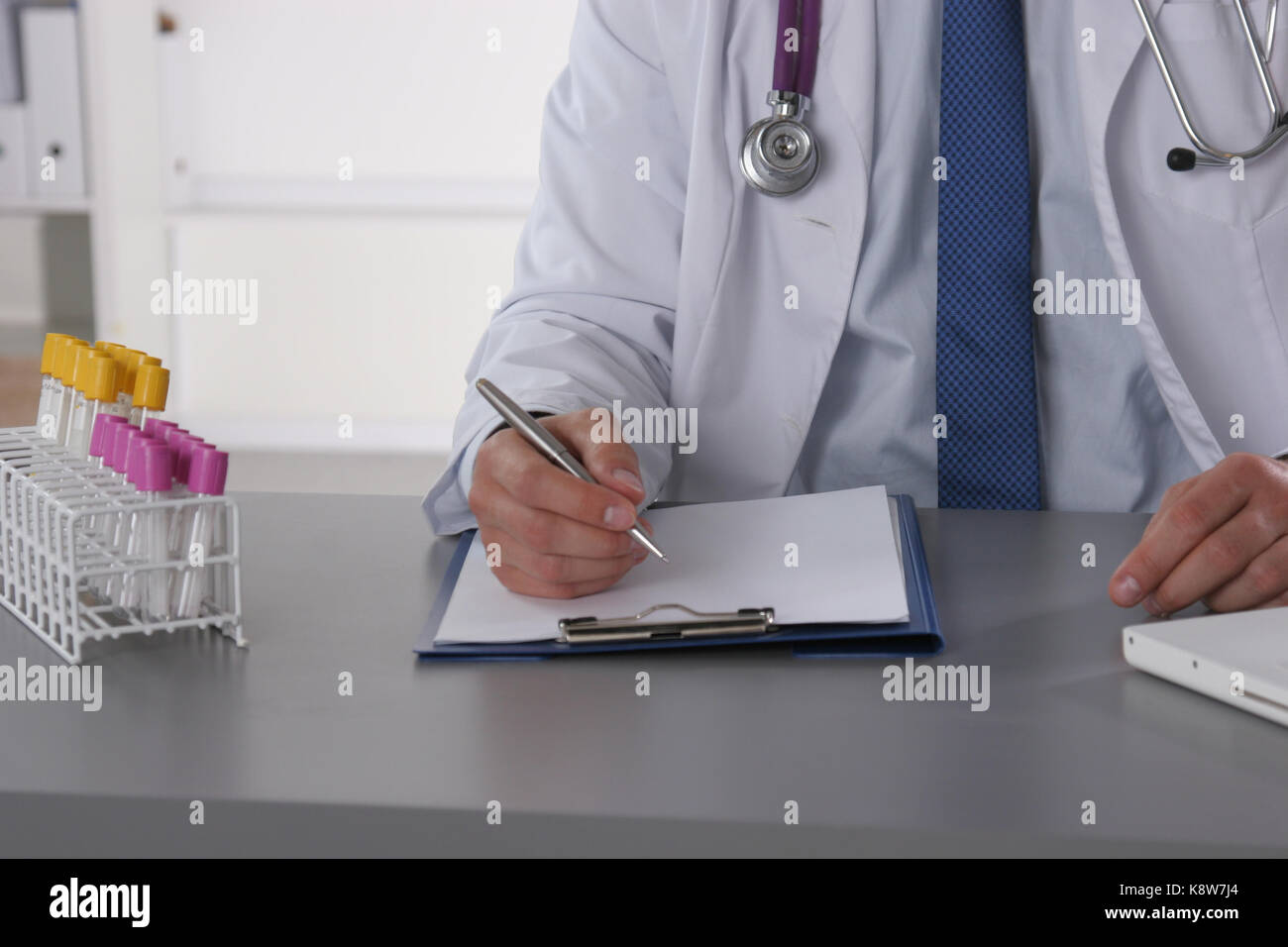 Male doctor write on the desk with test tube Stock Photo - Alamy