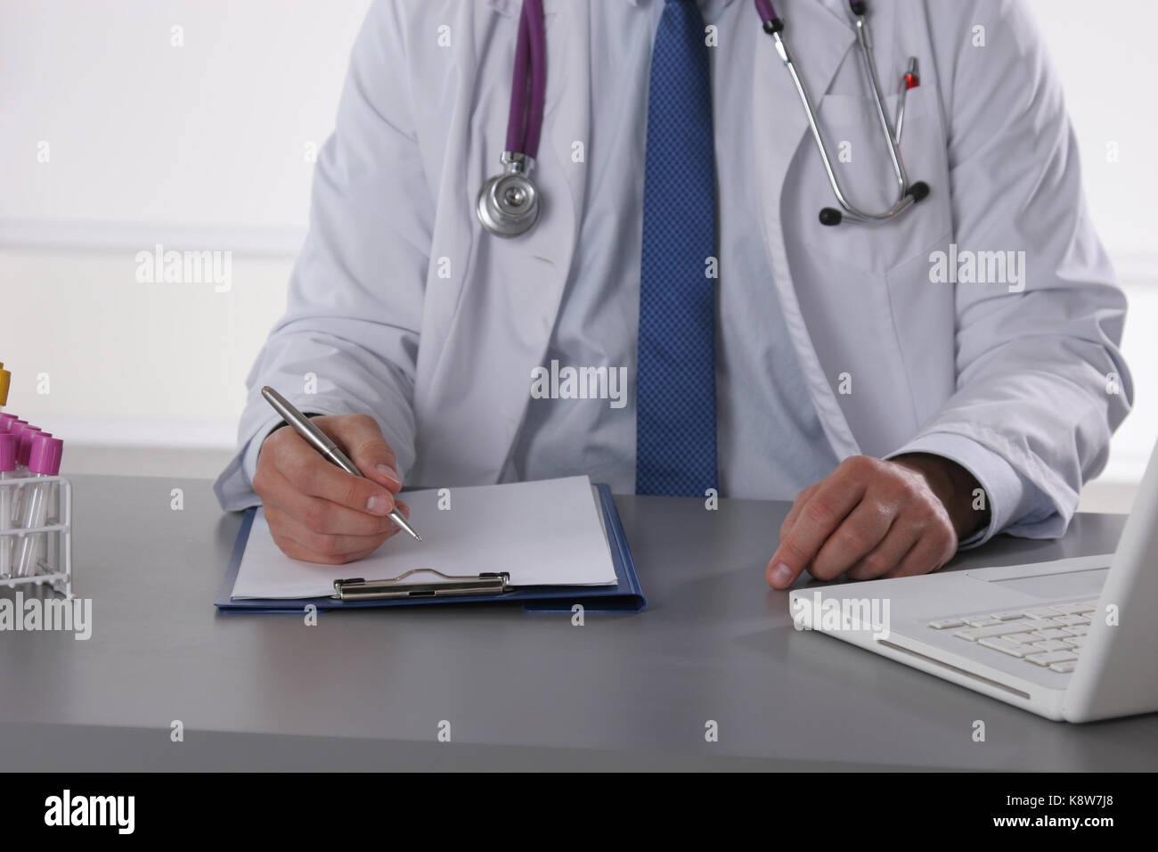 Male doctor write on the desk with test tube Stock Photo - Alamy