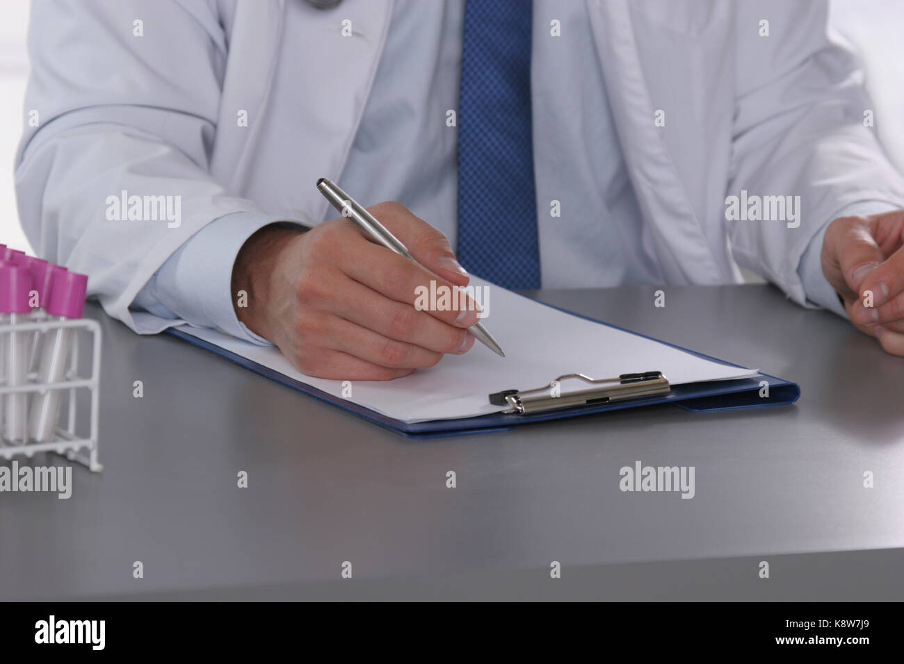 Male doctor write on the desk with test tube Stock Photo - Alamy