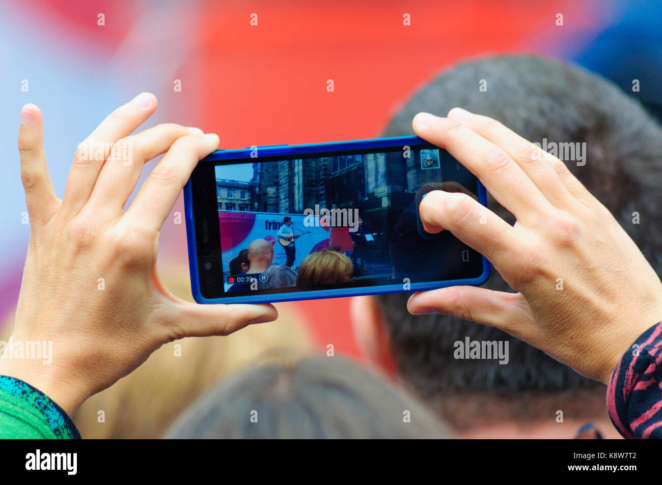 Hands holding a mobile phone video recording a performance on the Royal ...
