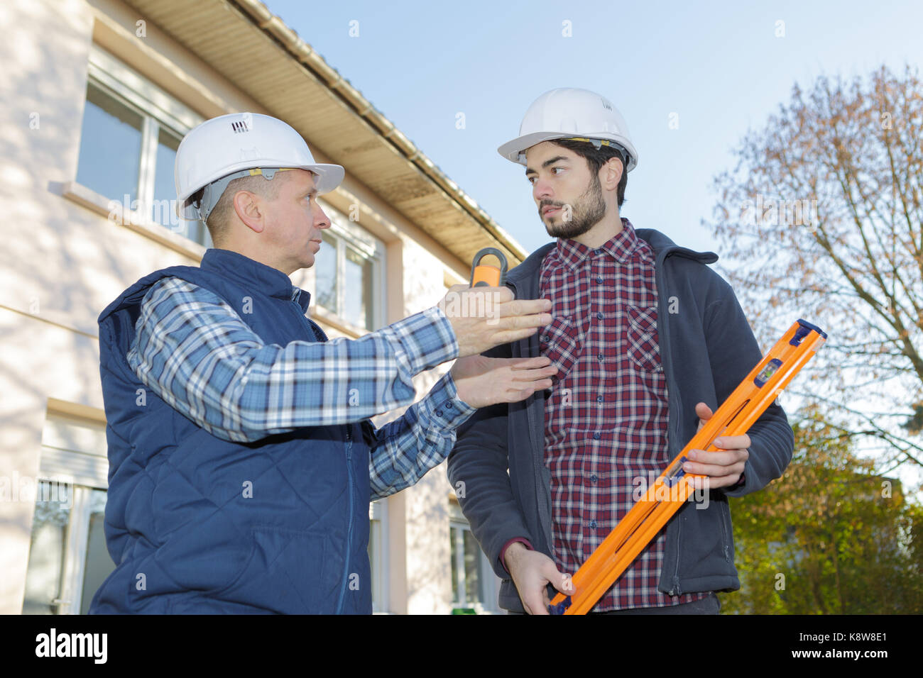 construction workers in discussion in the yard Stock Photo - Alamy