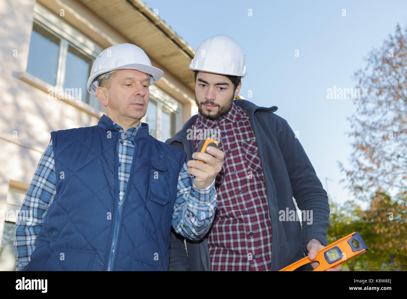 two construction workers taking measurements Stock Photo - Alamy