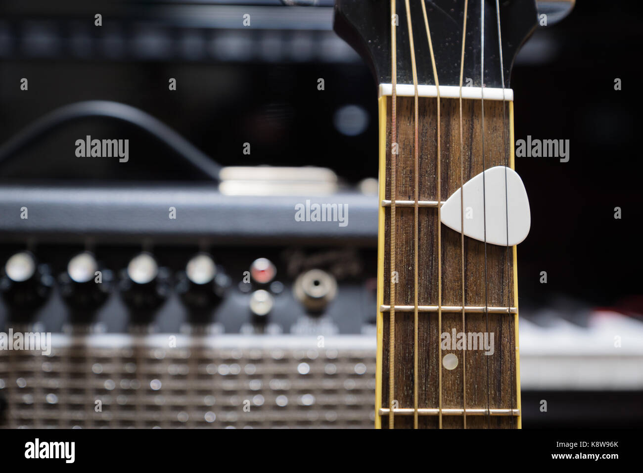 acoustic guitar against grand piano keys with plectrum - musical ...