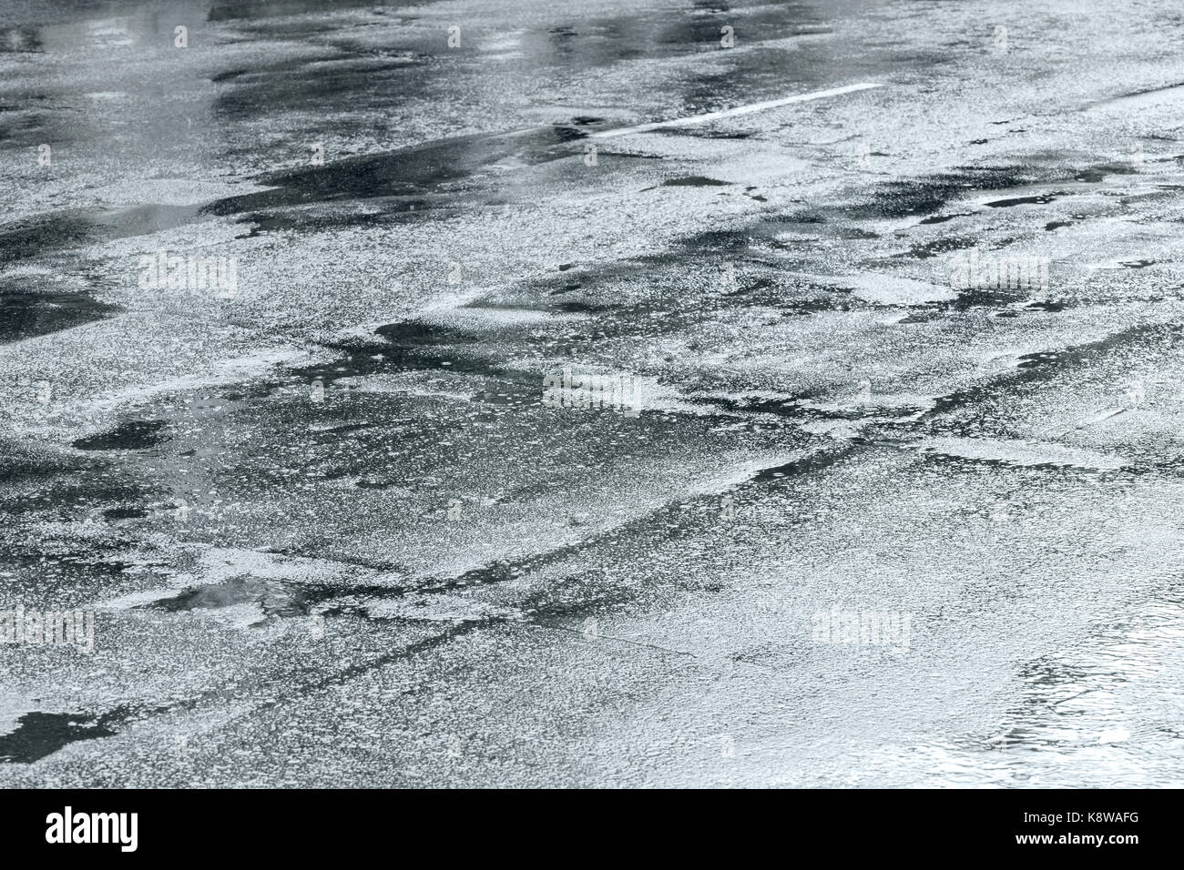 wet bumpy asphalt road with water puddles after rain Stock Photo - Alamy