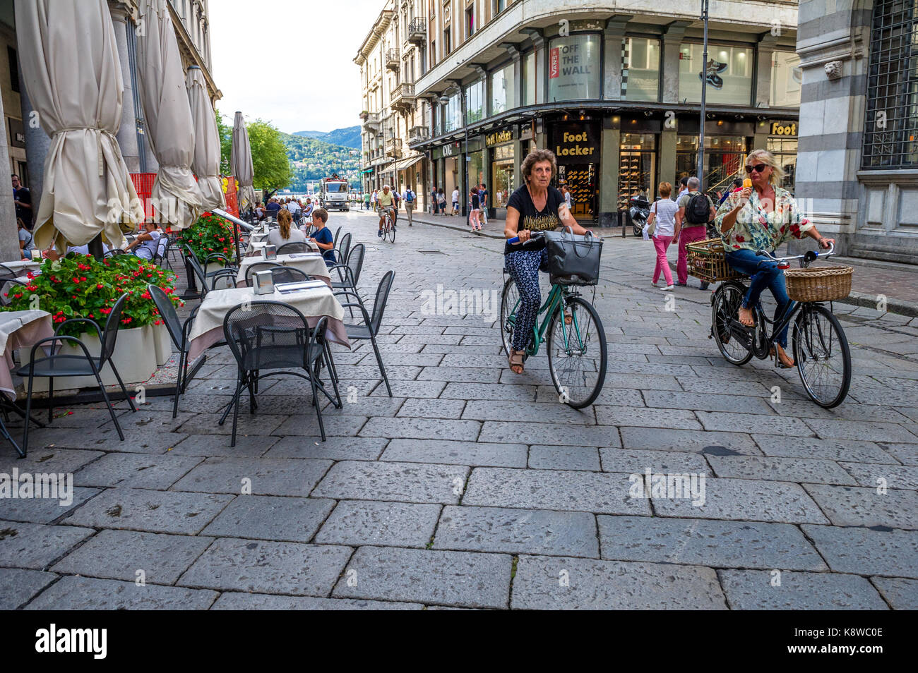 Female cyclist riding along a lane in the Italian city of Como Stock ...