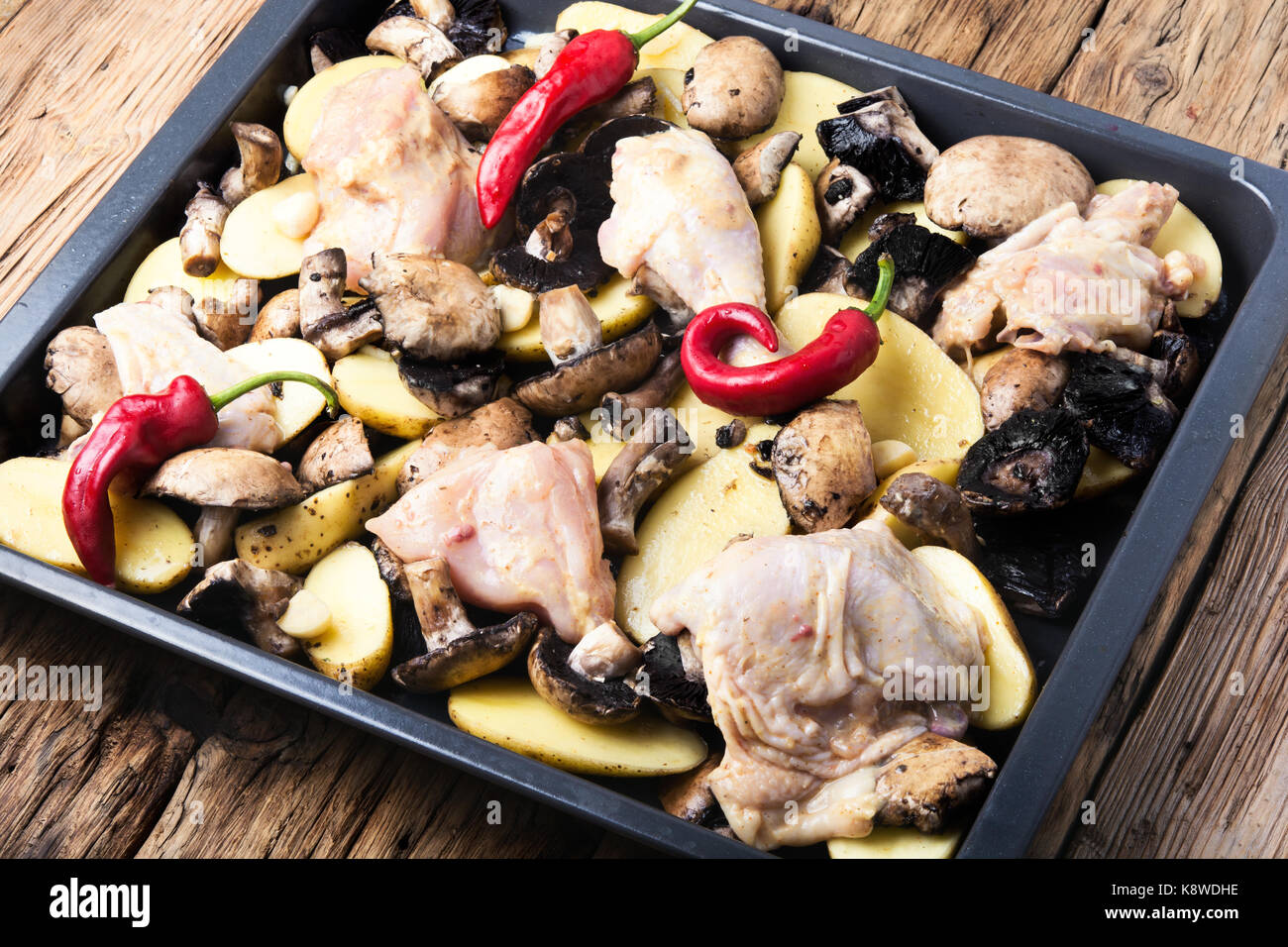 Raw chicken with raw potatoes in the form for baking Stock Photo - Alamy