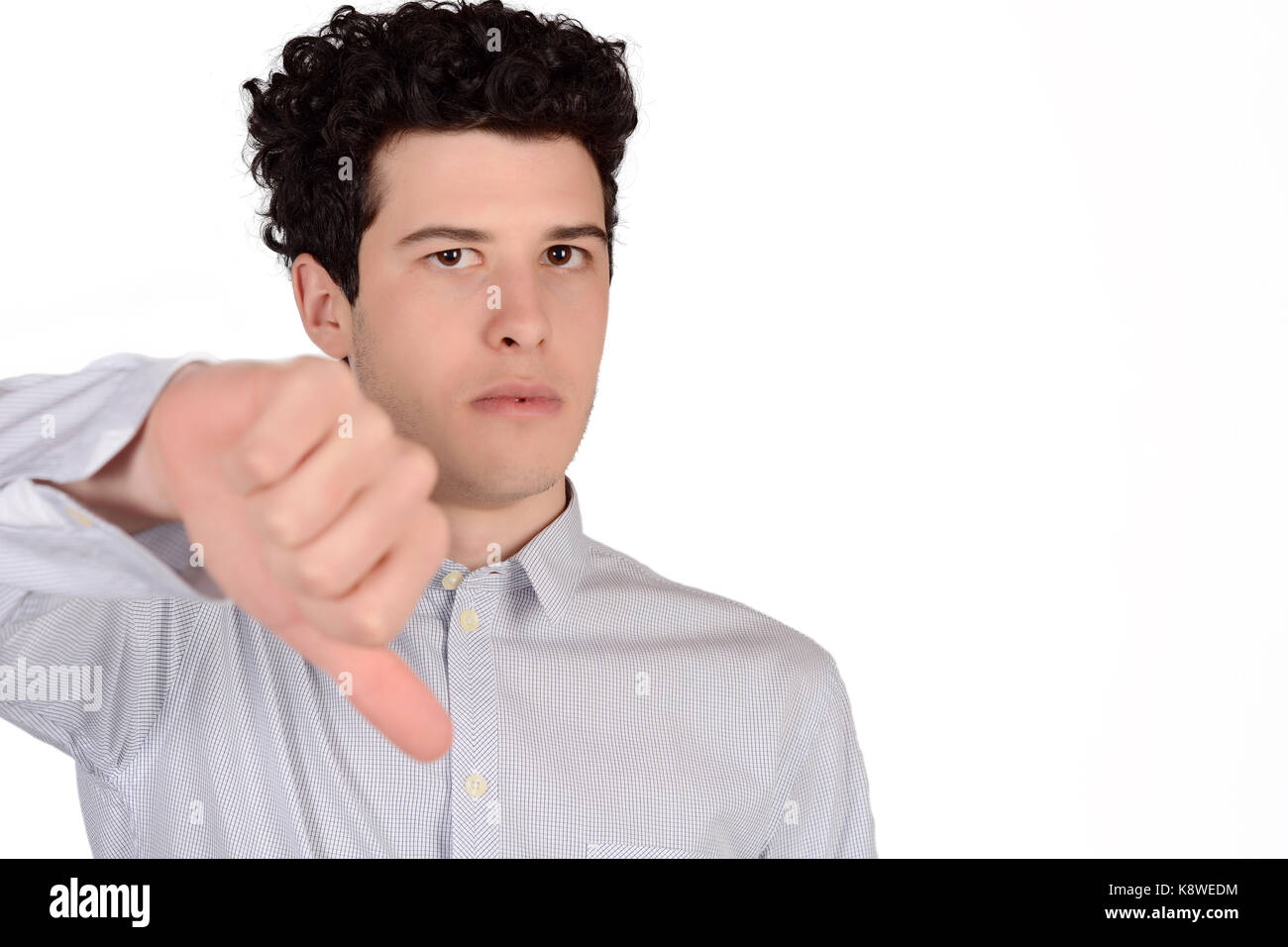 Portrait of young man with thumb down. Isolated white background Stock ...