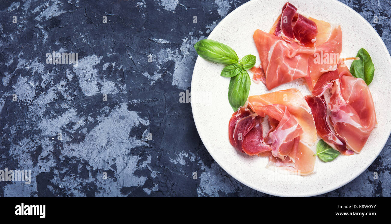 Traditional Spanish jamon on dark stone background Stock Photo - Alamy