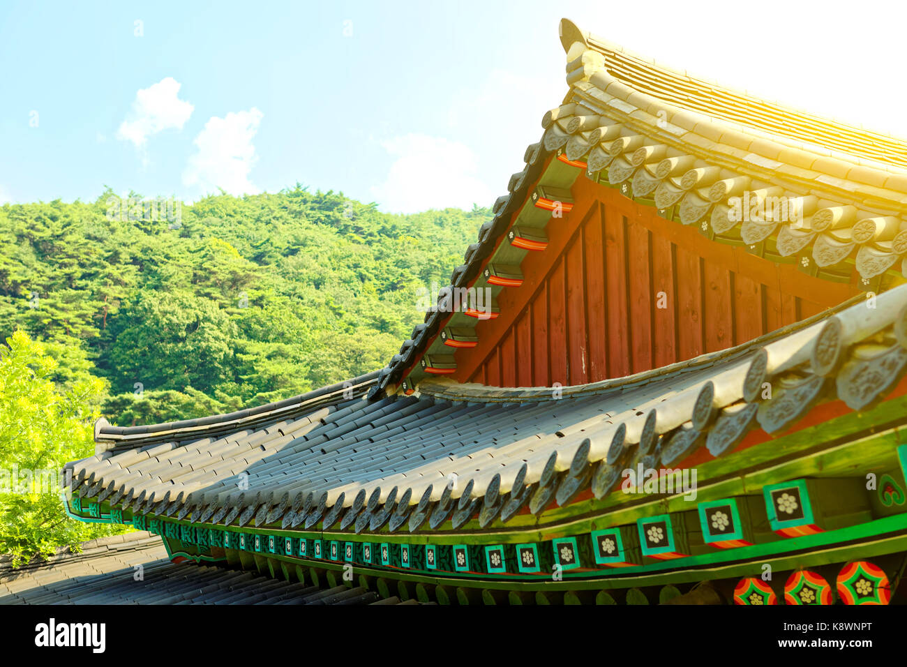 Sun flare seen above the roof element of a buddhist monastery located ...
