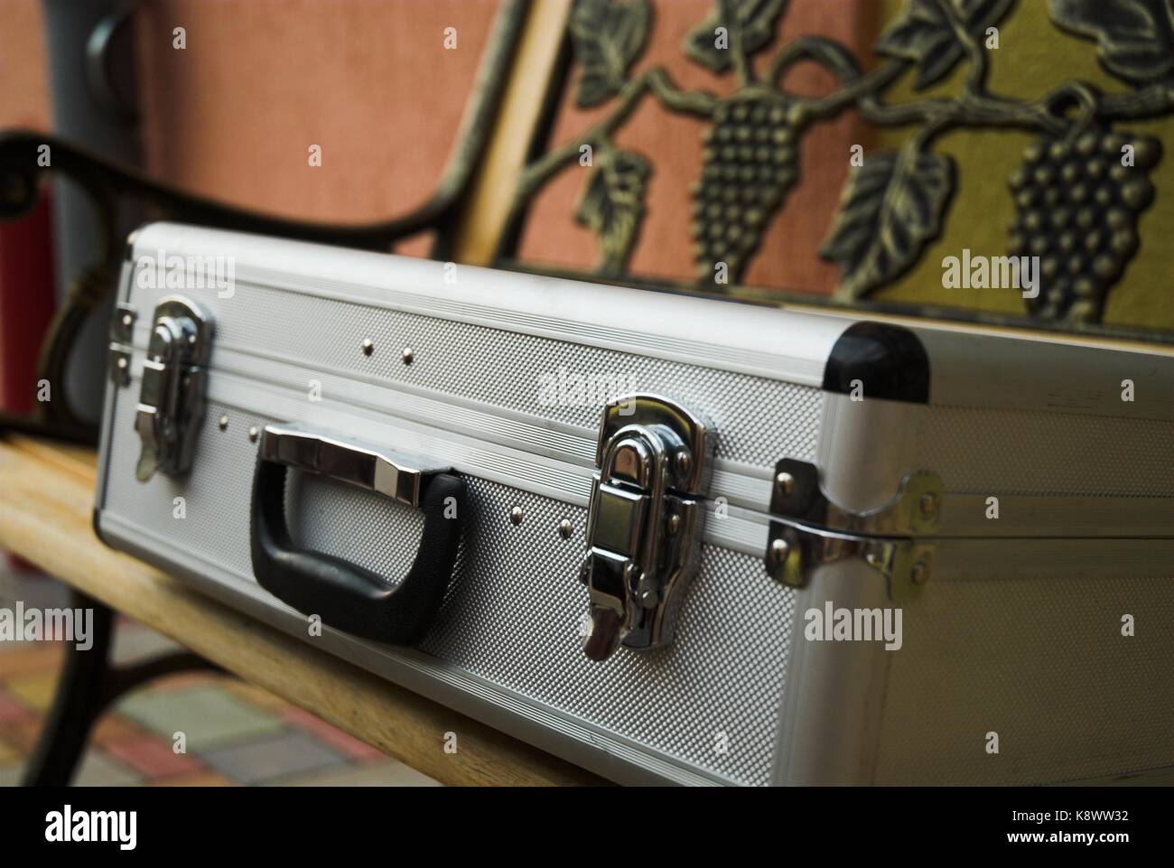 Locked metal suitcase is lying on the bench Stock Photo - Alamy