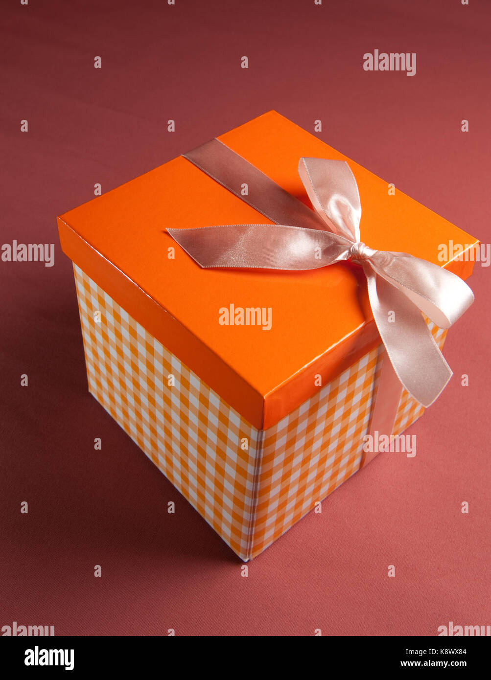 Orange present box with pink bow on textile background Stock Photo - Alamy