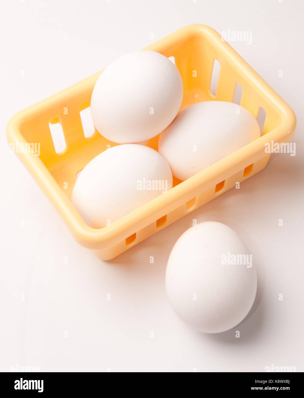 White eggs in plastic box on white background Stock Photo - Alamy