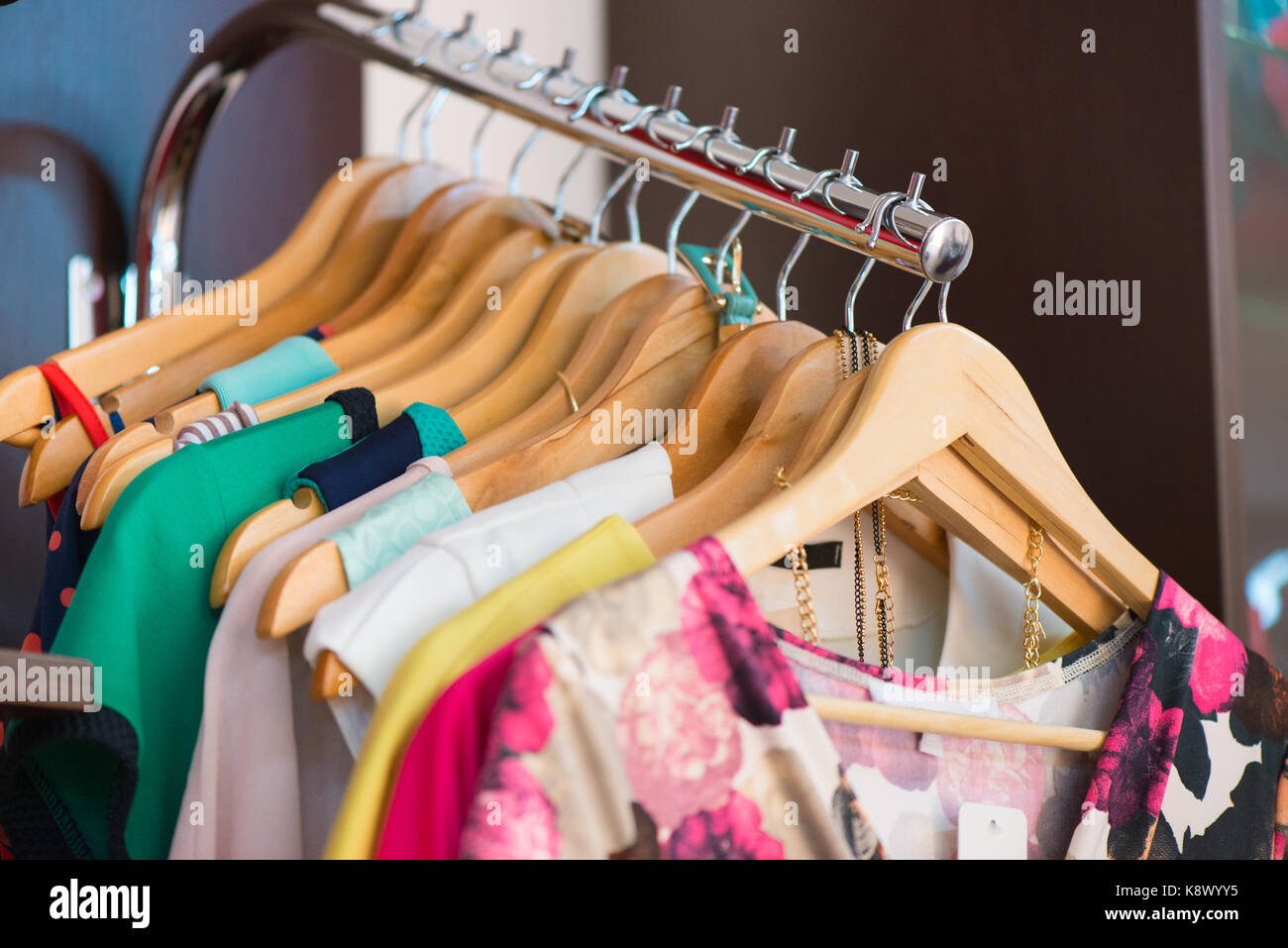 Variety of clothes hanging on rack in boutique Stock Photo - Alamy