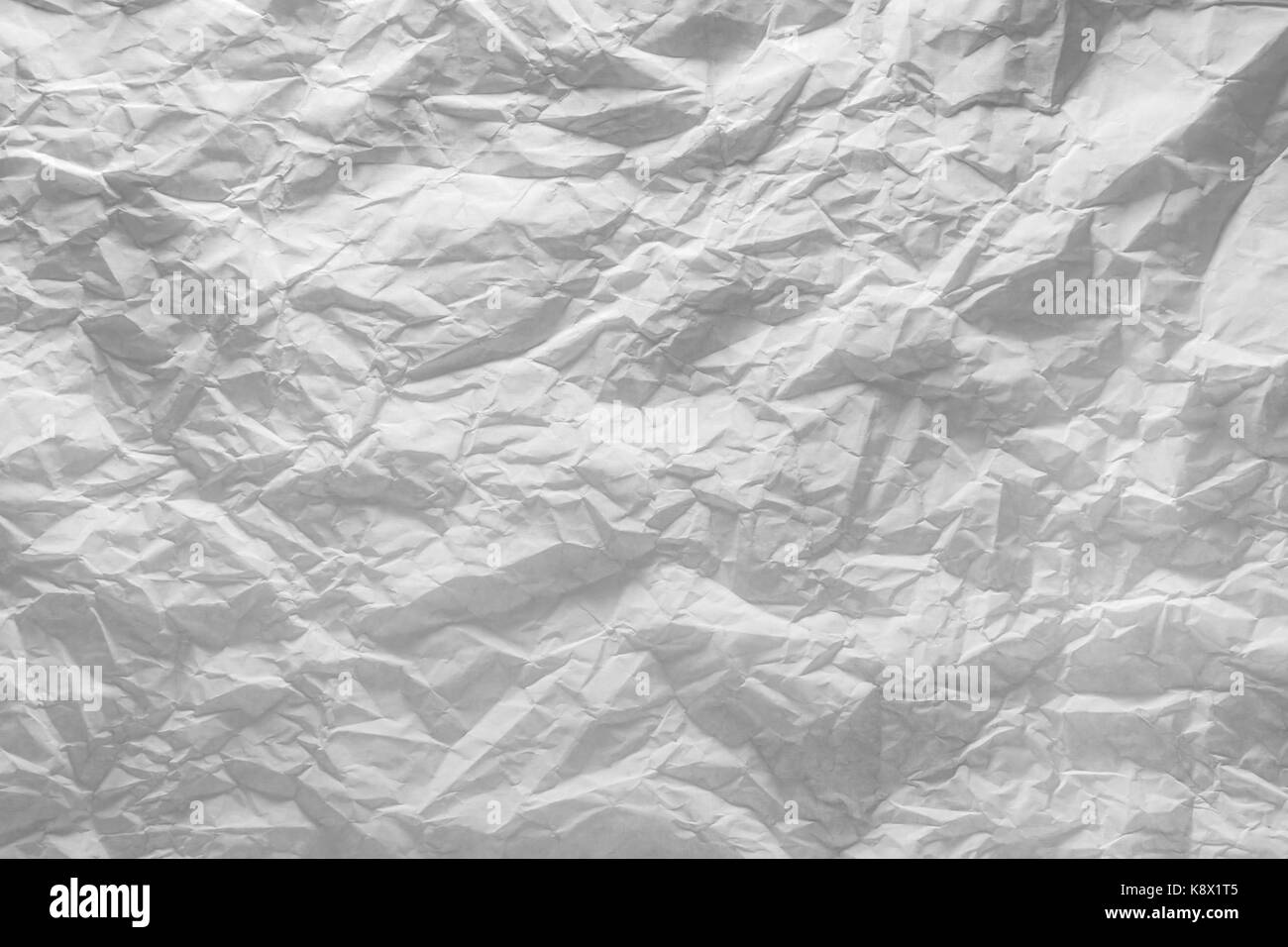 Surface of crumpled paper highlighted by light. Stressed, illuminated ...