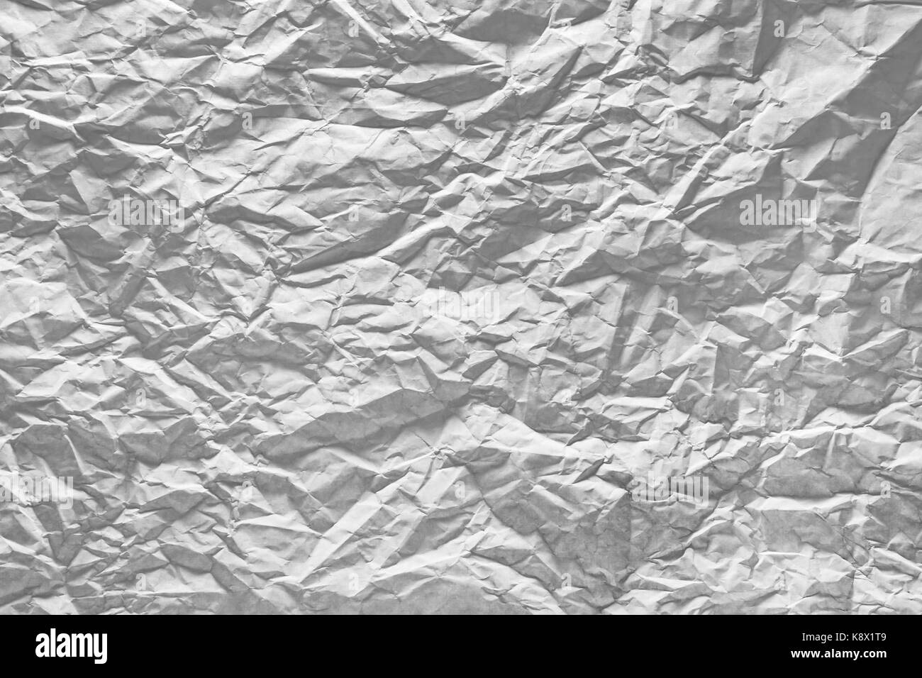 Surface of crumpled paper highlighted by light. Stressed, illuminated ...