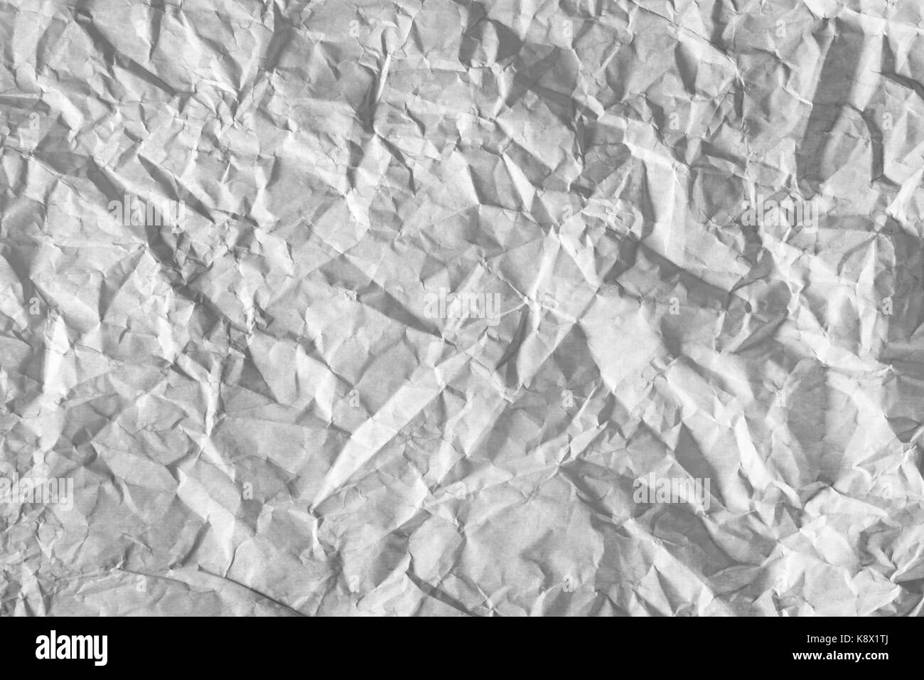 Surface of crumpled paper highlighted by light. Stressed, illuminated ...