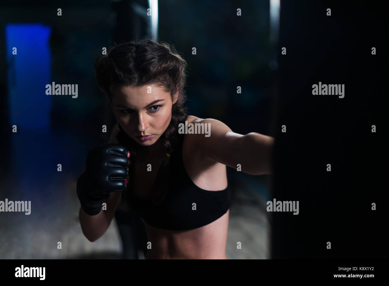 Young fighter boxer fit girl wearing boxing gloves in training with ...