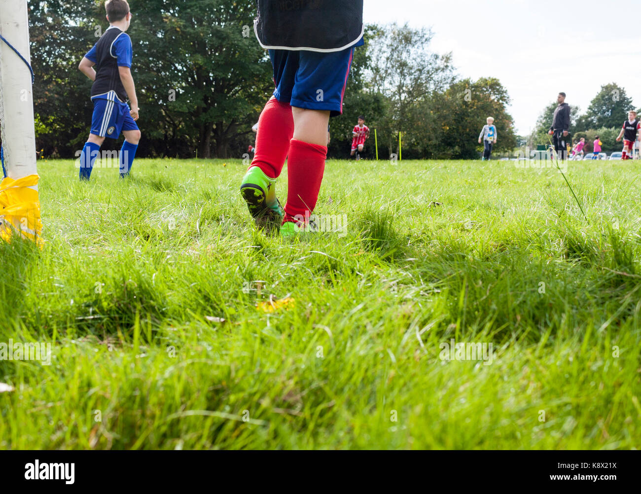 A low angle view of young boys playing football outside Stock Photo - Alamy