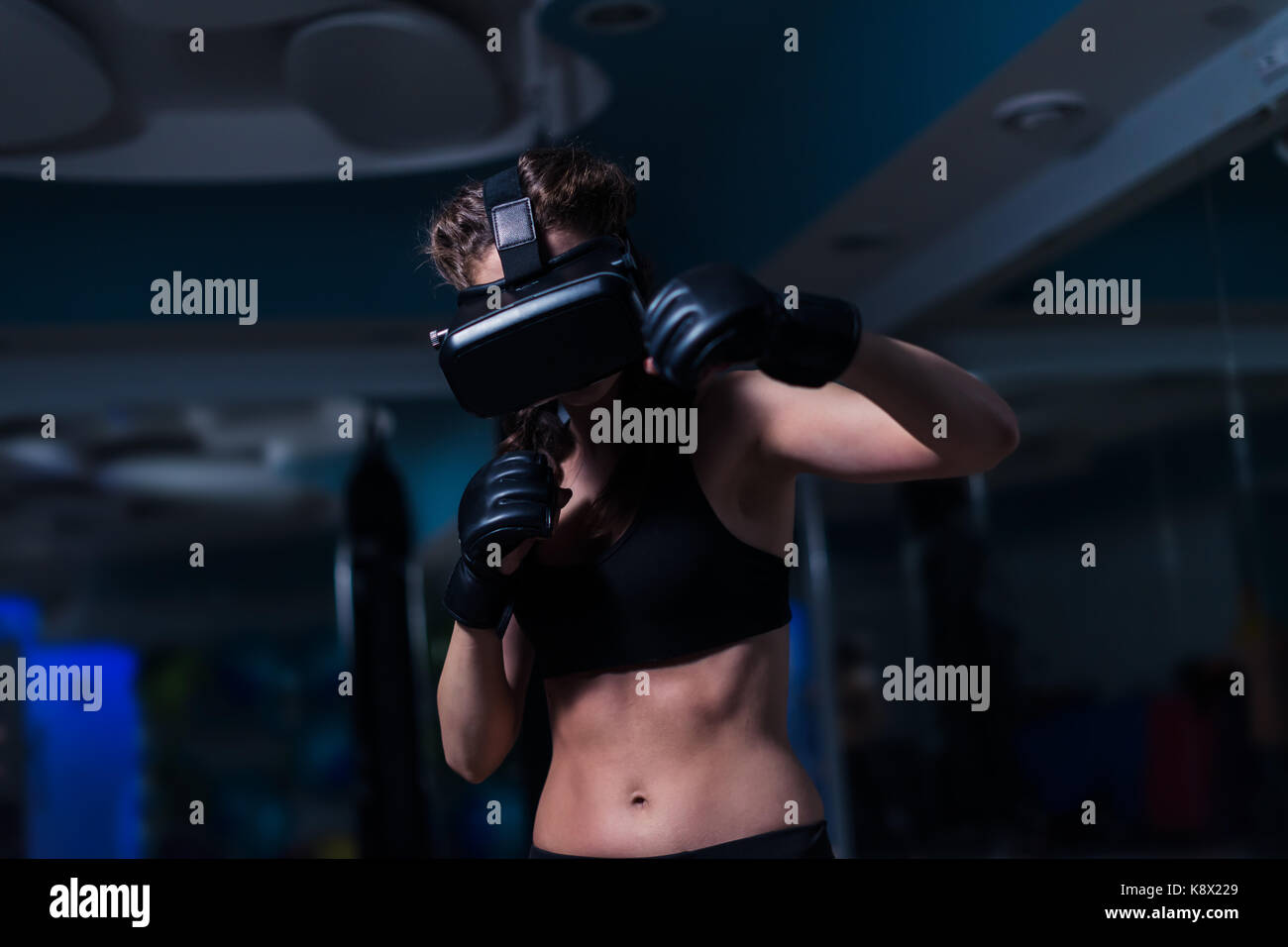 Young fighter boxer fit girl punching in VR glasses wearing boxing ...
