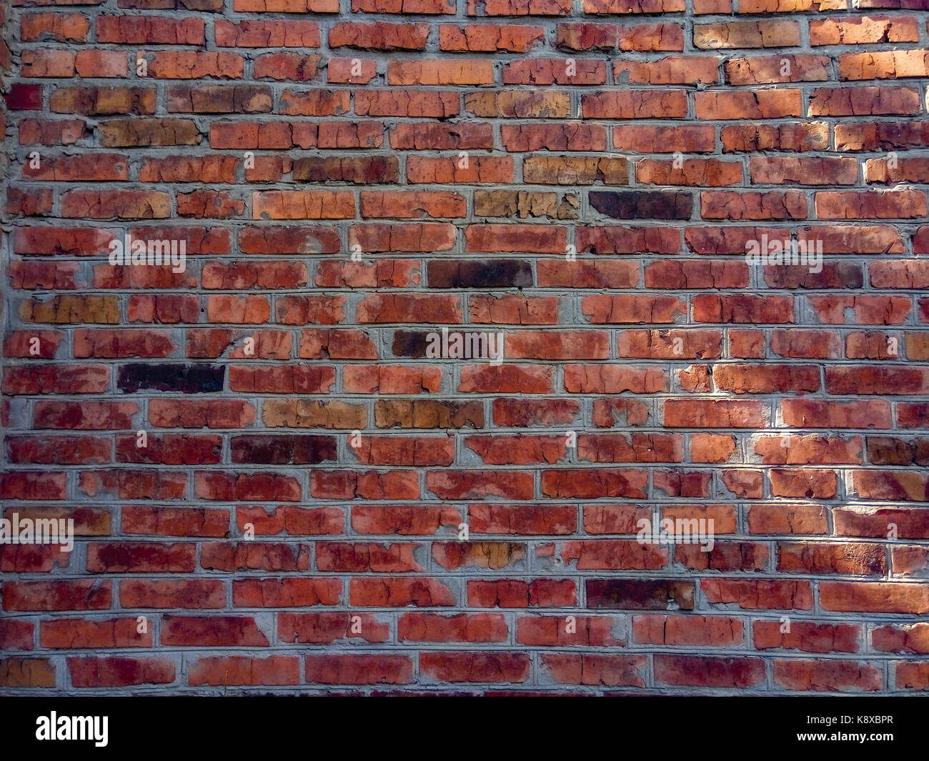 A close-up shot of a rough brick masonry wall lined with red clumsy ...