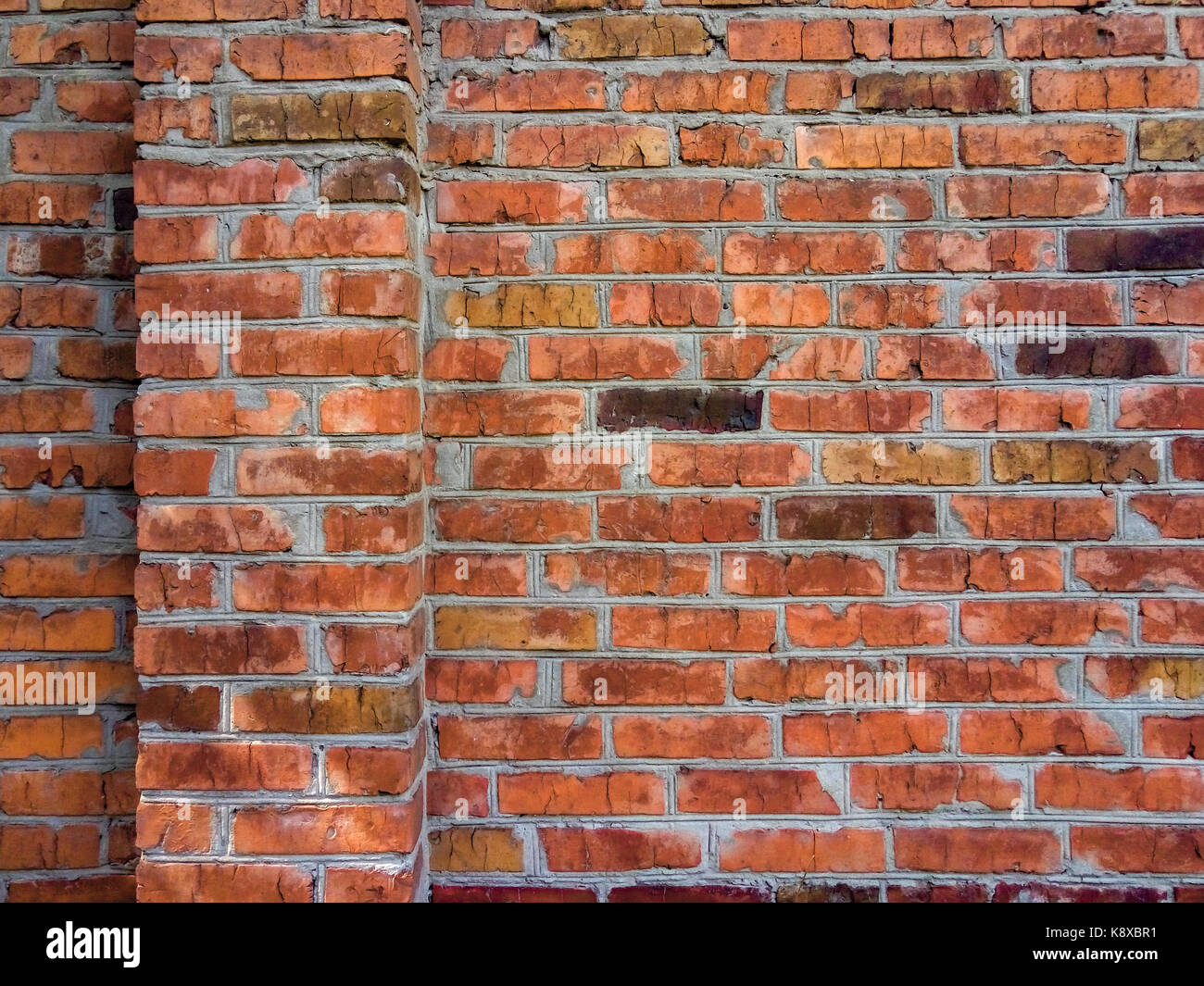 A close-up shot of a rough brick masonry wall lined with red clumsy ...