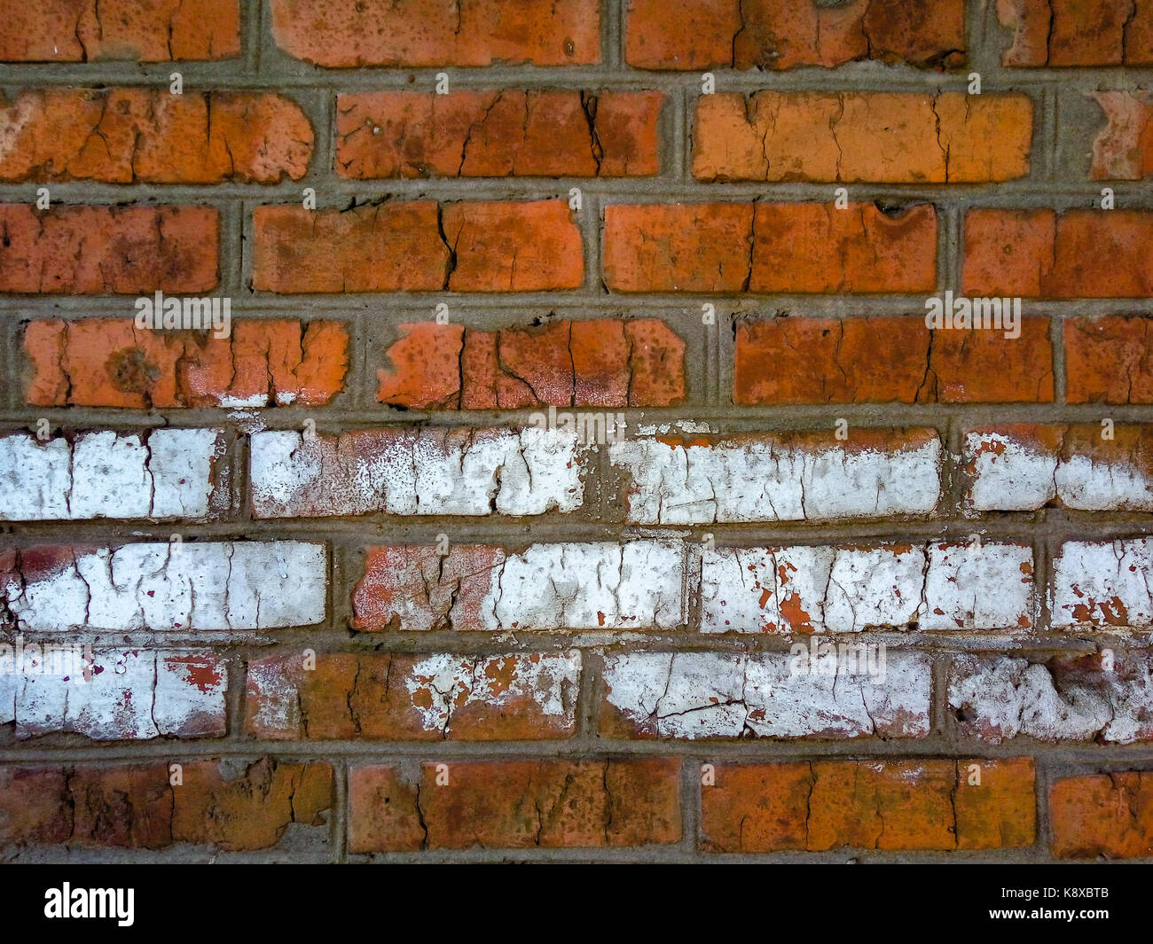A close-up shot of a rough brick masonry wall lined with red clumsy ...