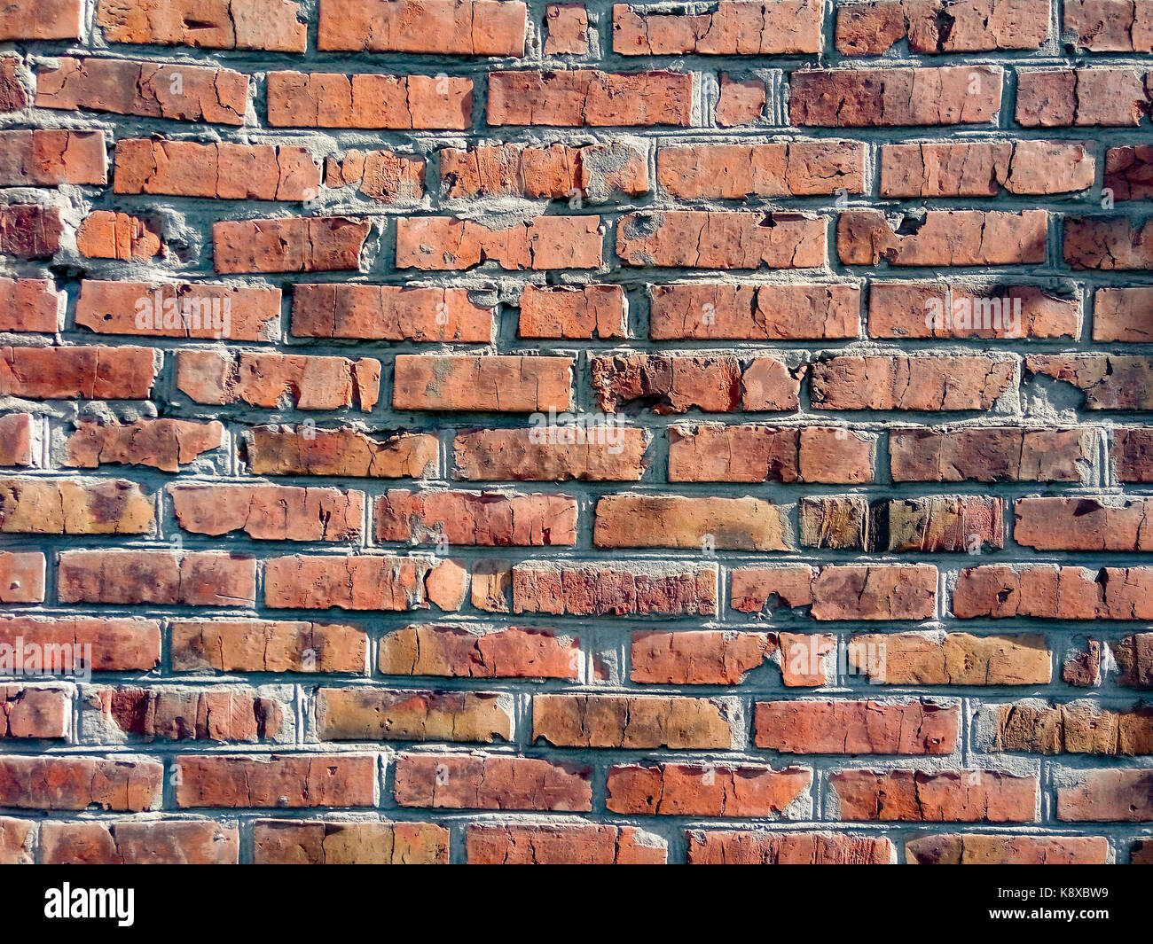 A close-up shot of a rough brick masonry wall lined with red clumsy ...