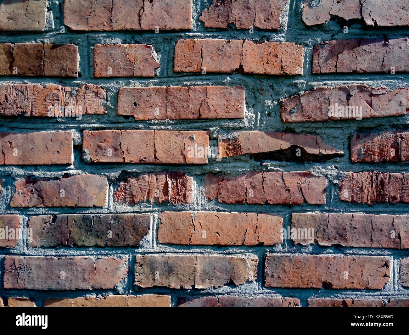 A close-up shot of a rough brick masonry wall lined with red clumsy ...