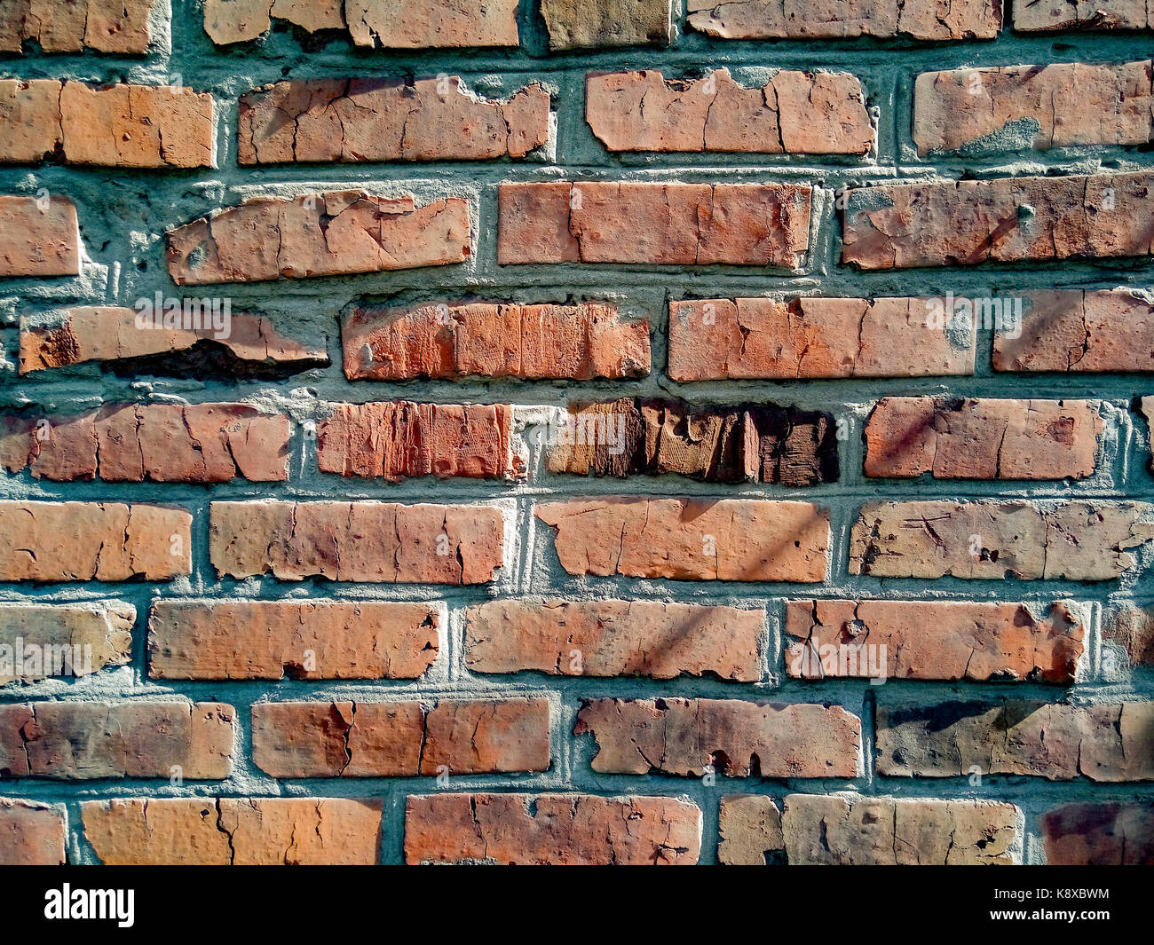 A close-up shot of a rough brick masonry wall lined with red clumsy ...