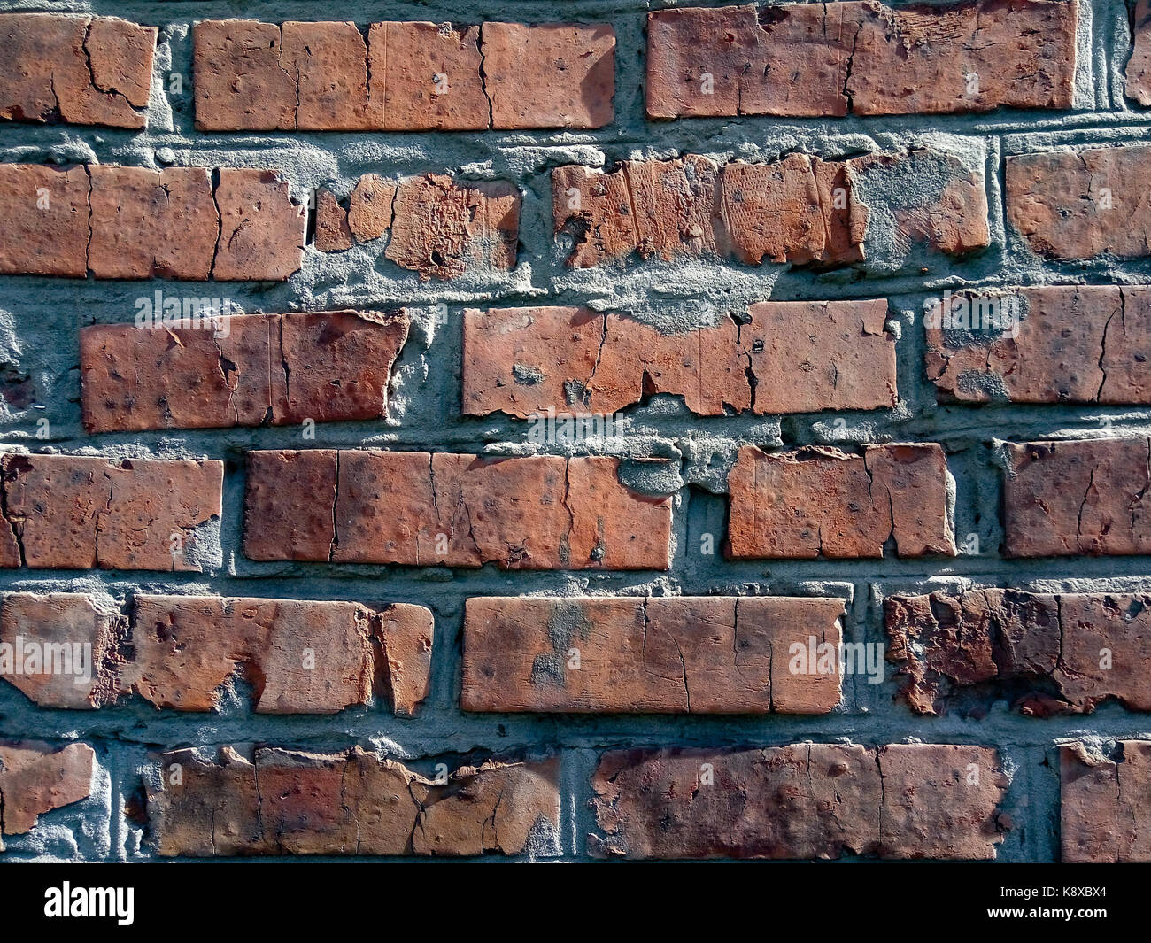 A close-up shot of a rough brick masonry wall lined with red clumsy ...