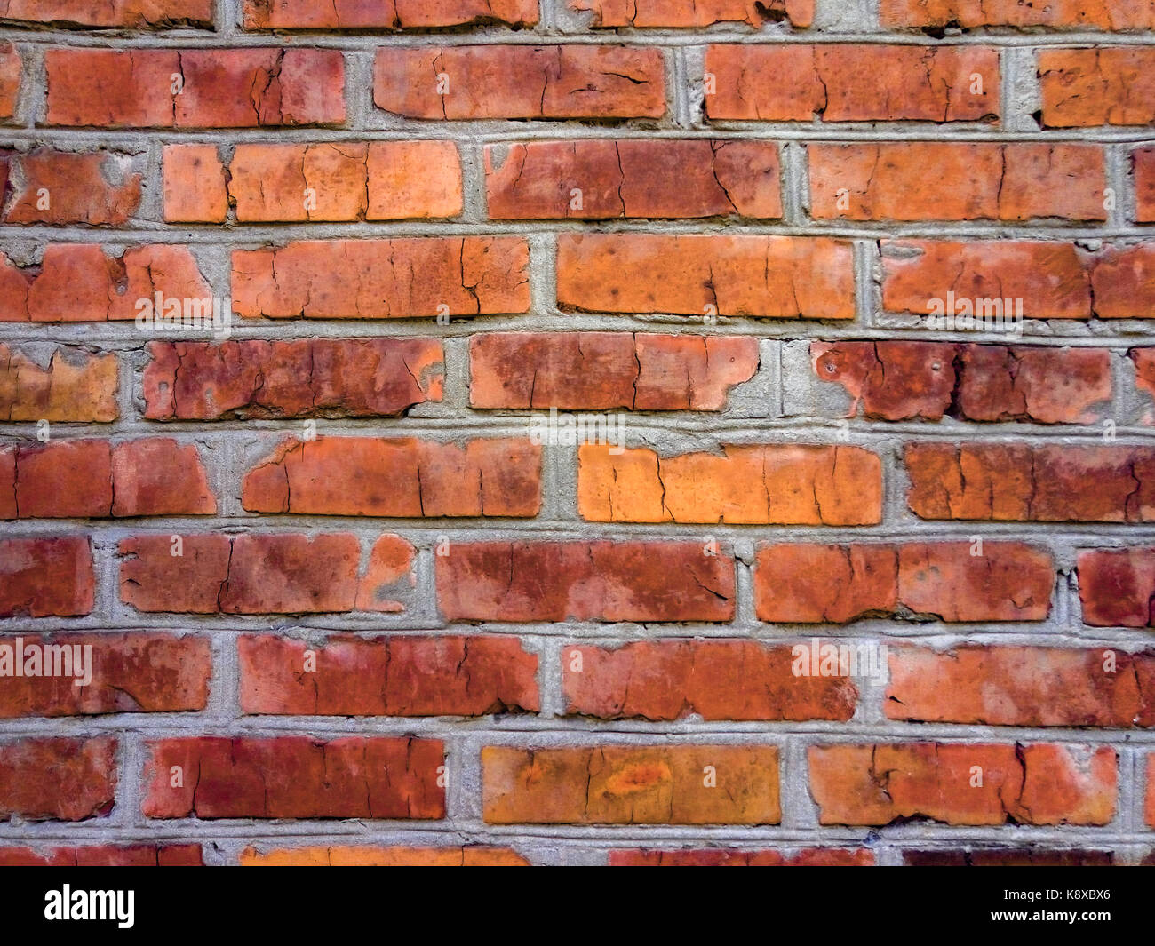 A close-up shot of a rough brick masonry wall lined with red clumsy ...