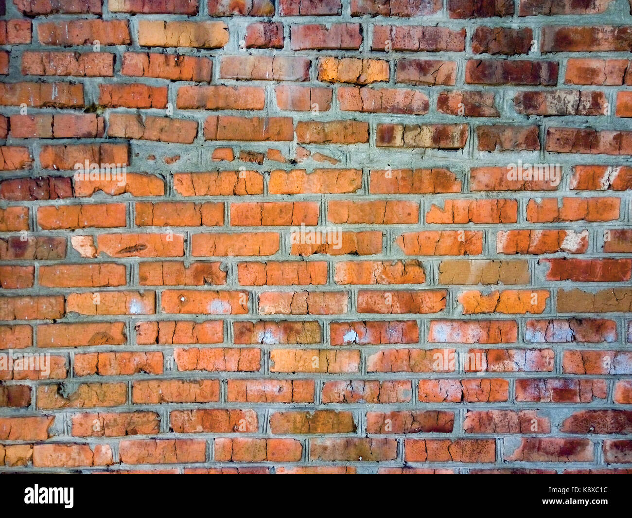 A close-up shot of a rough brick masonry wall lined with red clumsy ...