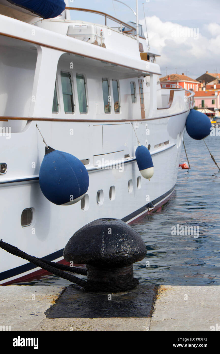 A short, thick post on the deck of a ship or on a wharf, to which a ...