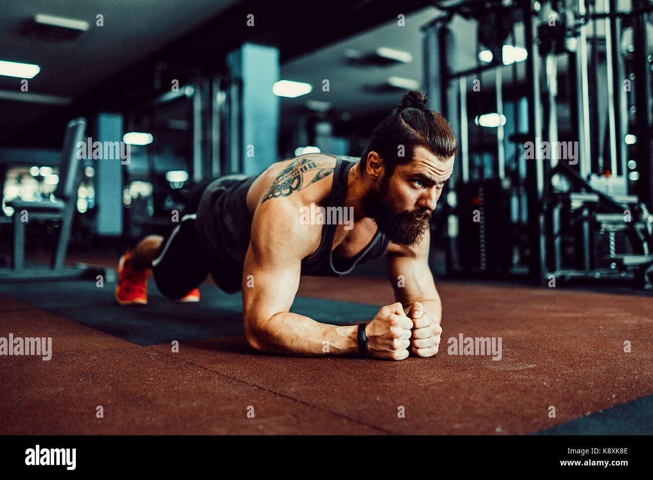 Muscled young man wearing sport wear and doing plank position while ...