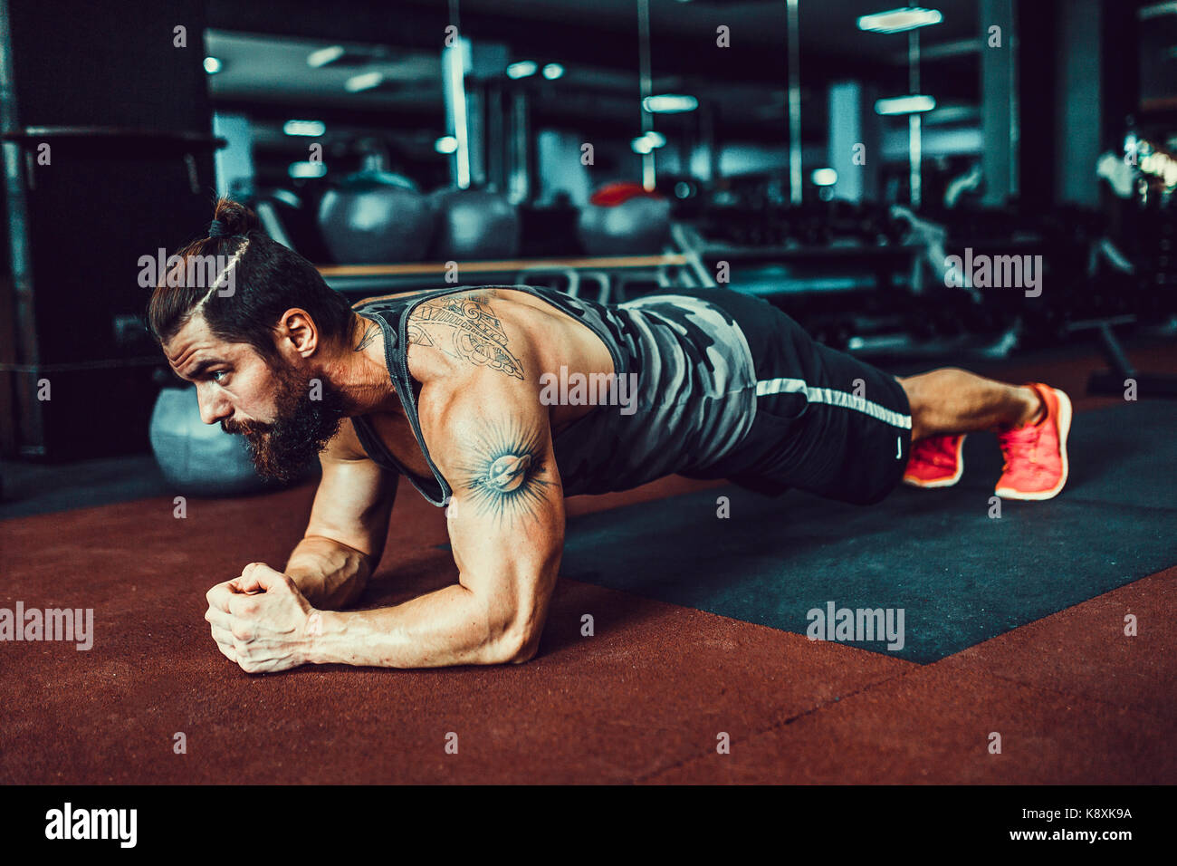 Muscled young man wearing sport wear and doing plank position while ...