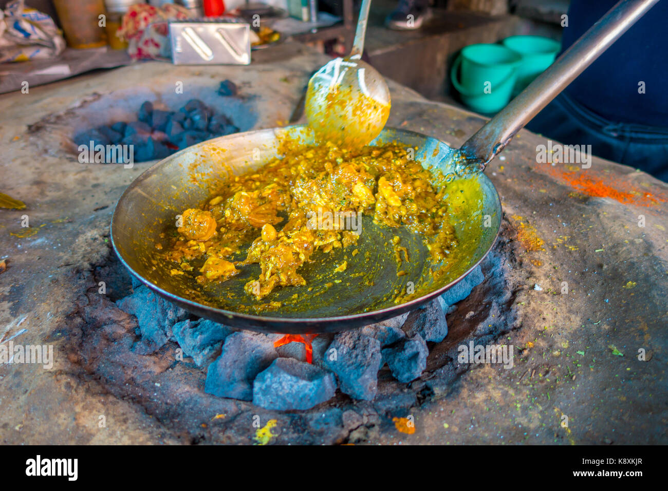Close up of Indian food cooked in a metallic tray over incandescent ...
