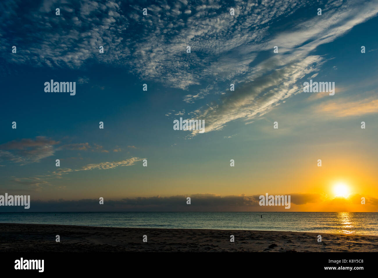 morning sun and blue sky over the ocean on a calm morning Stock Photo ...