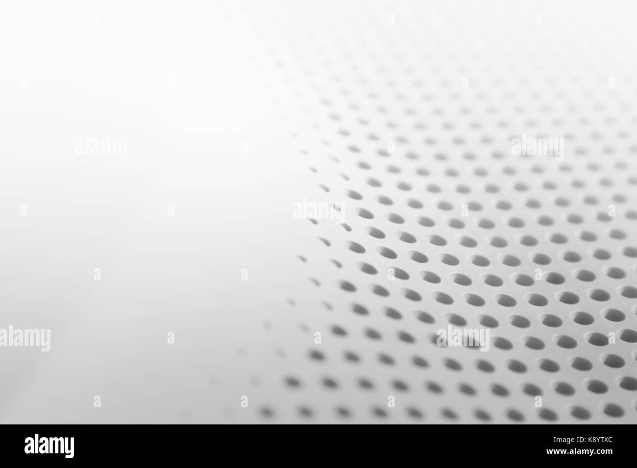 Abstract light colored surface with holes built in a row for creativity ...