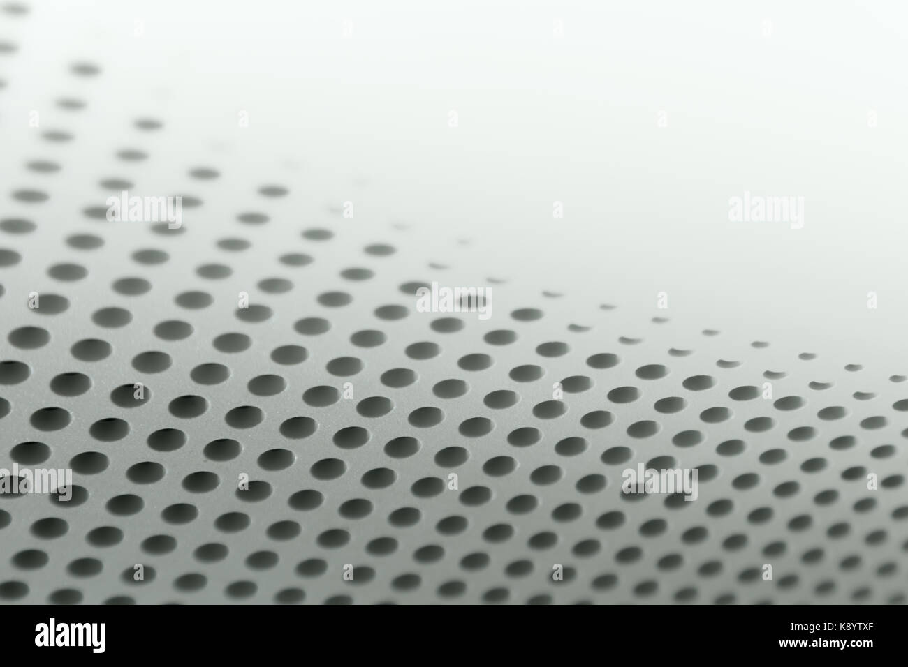 Abstract light colored surface with holes built in a row for creativity ...