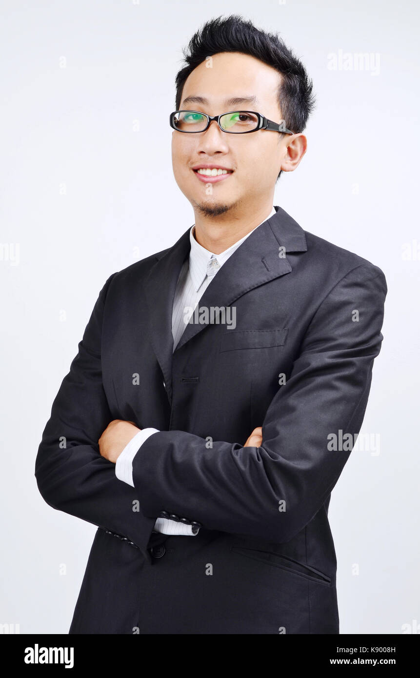Portrait of smart Asian businessman arms crossed smiling and looking at ...