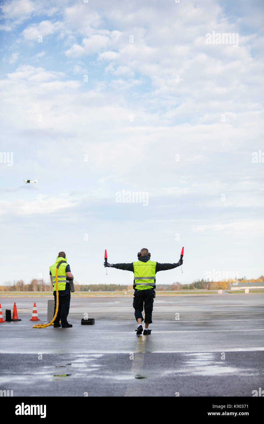 Marshaller Holding Signal Wands While Standing By Colleague On R Stock ...