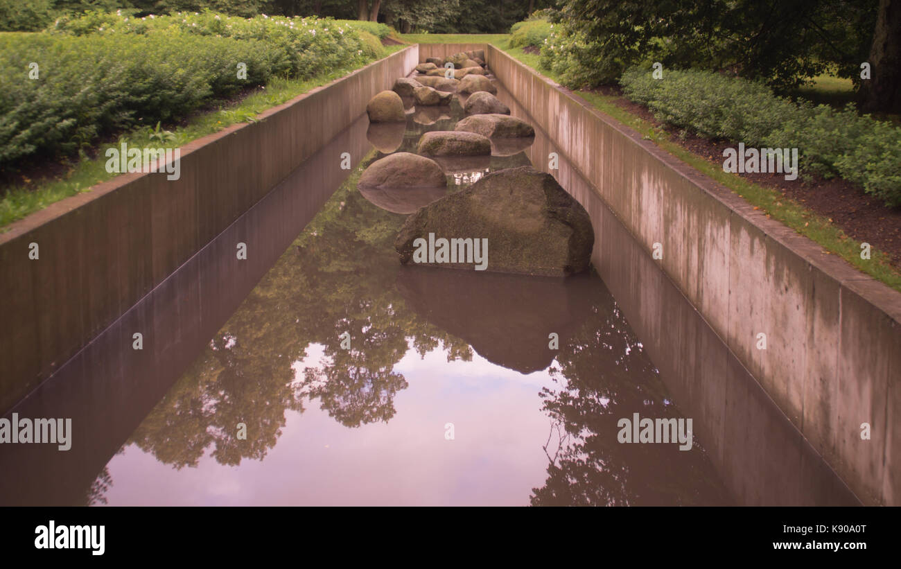 Pond channel with stones in park background Stock Photo - Alamy