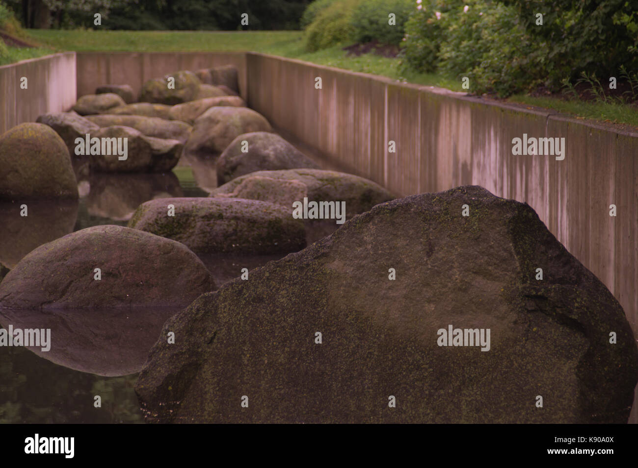 Pond channel with stones in park background Stock Photo - Alamy