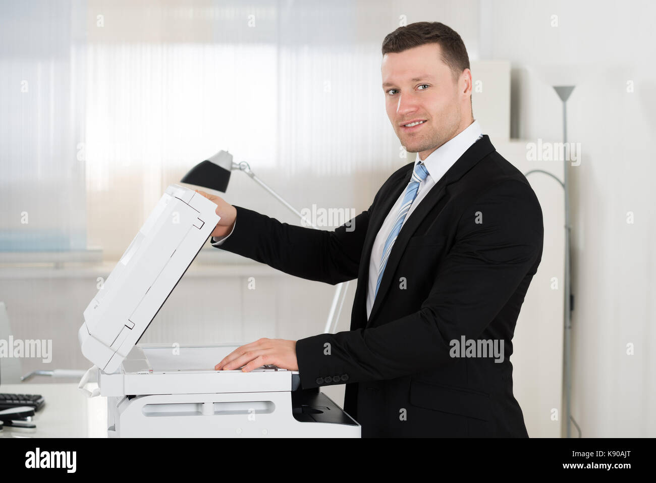 Side view portrait of businessman using photocopy machine in office ...