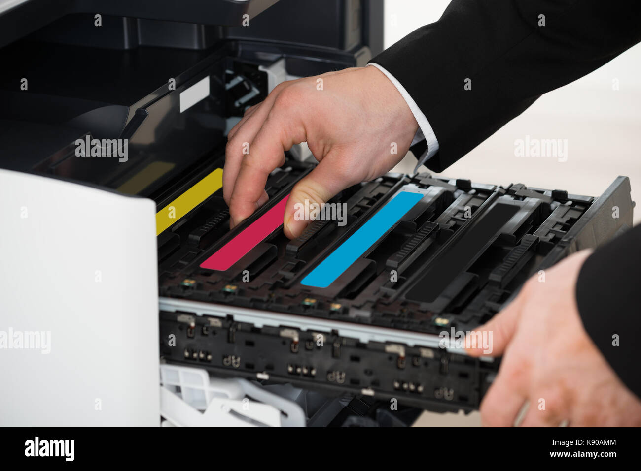 Cropped image of businessman fixing cartridge in photocopy machine at ...