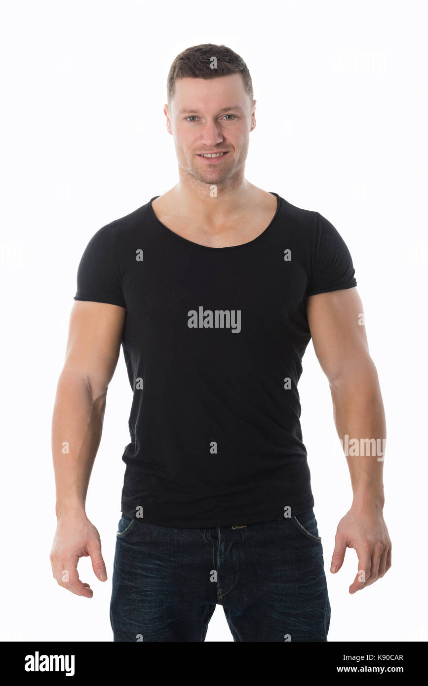 Handsome mid adult man in black tshirt standing with hands in pockets ...