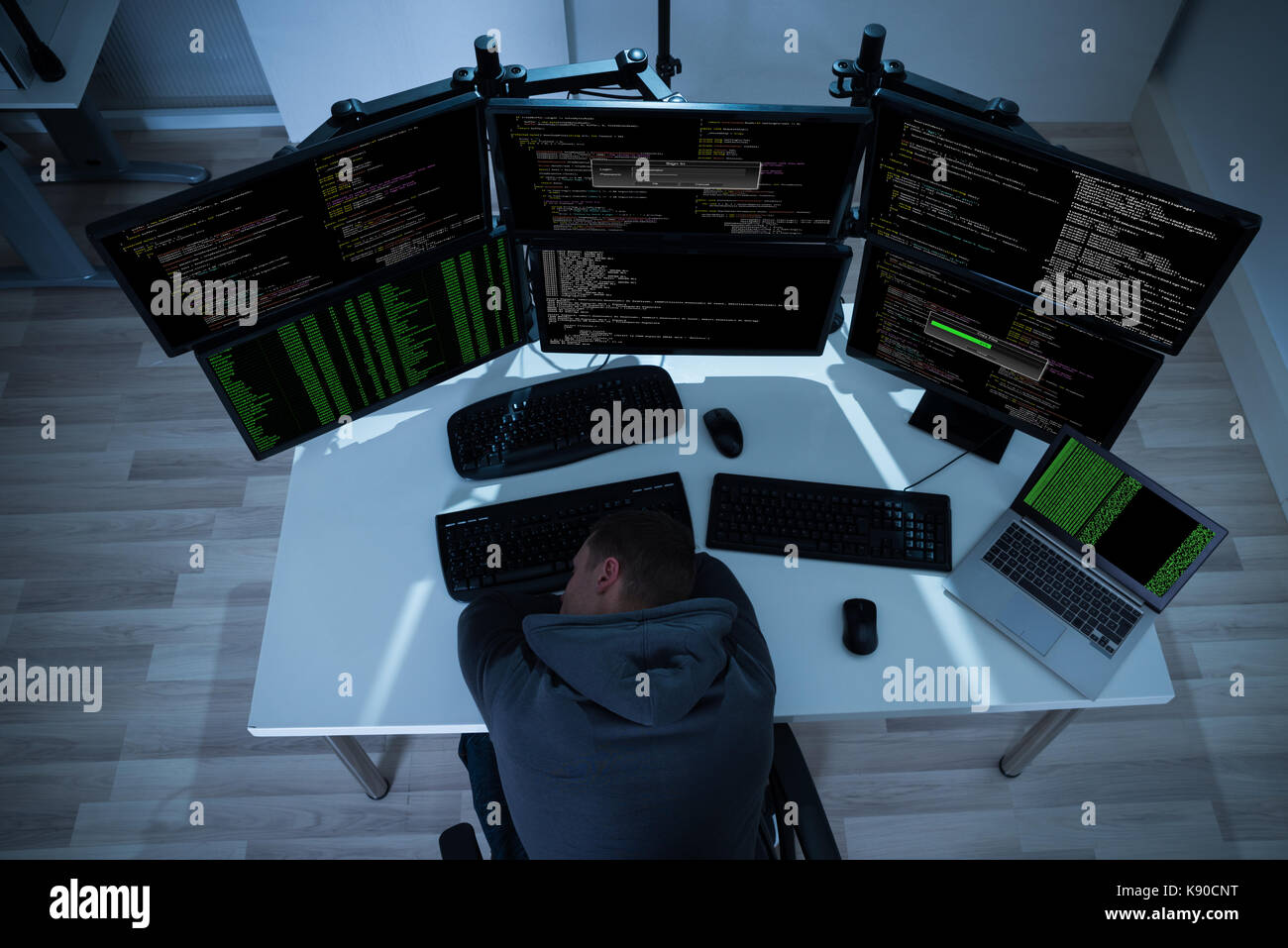 High angle view of tired hacker sleeping near computers at night Stock ...