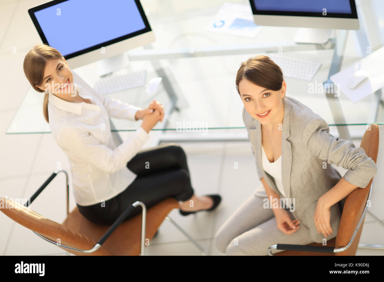 view from the top. two women colleagues sitting near the desktop Stock ...